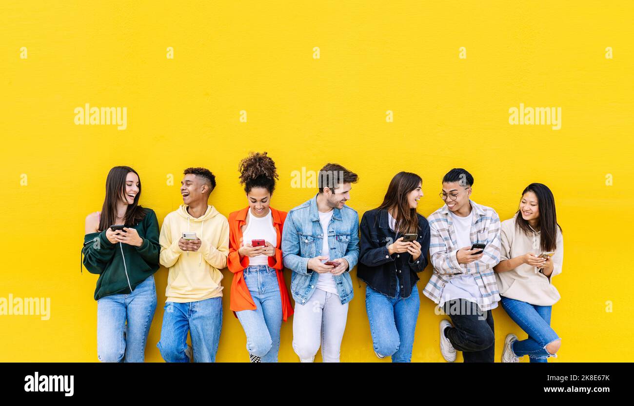 Multiracial young friends having fun sharing media content on mobile ...