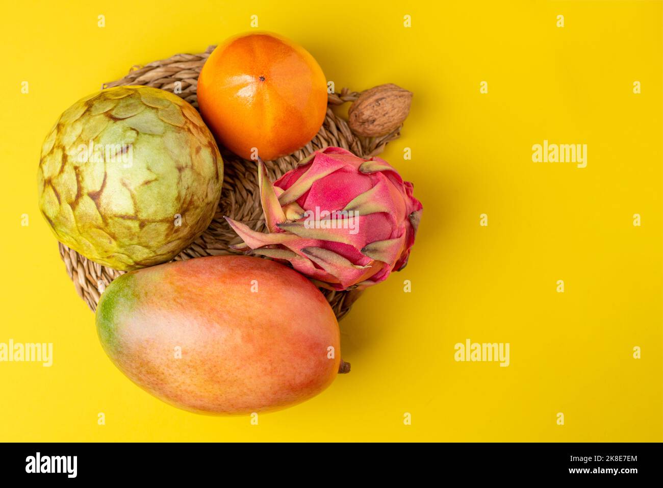 Autumn tropical fruits,mango,custard apple,pitahaya and persimmon, on a ...
