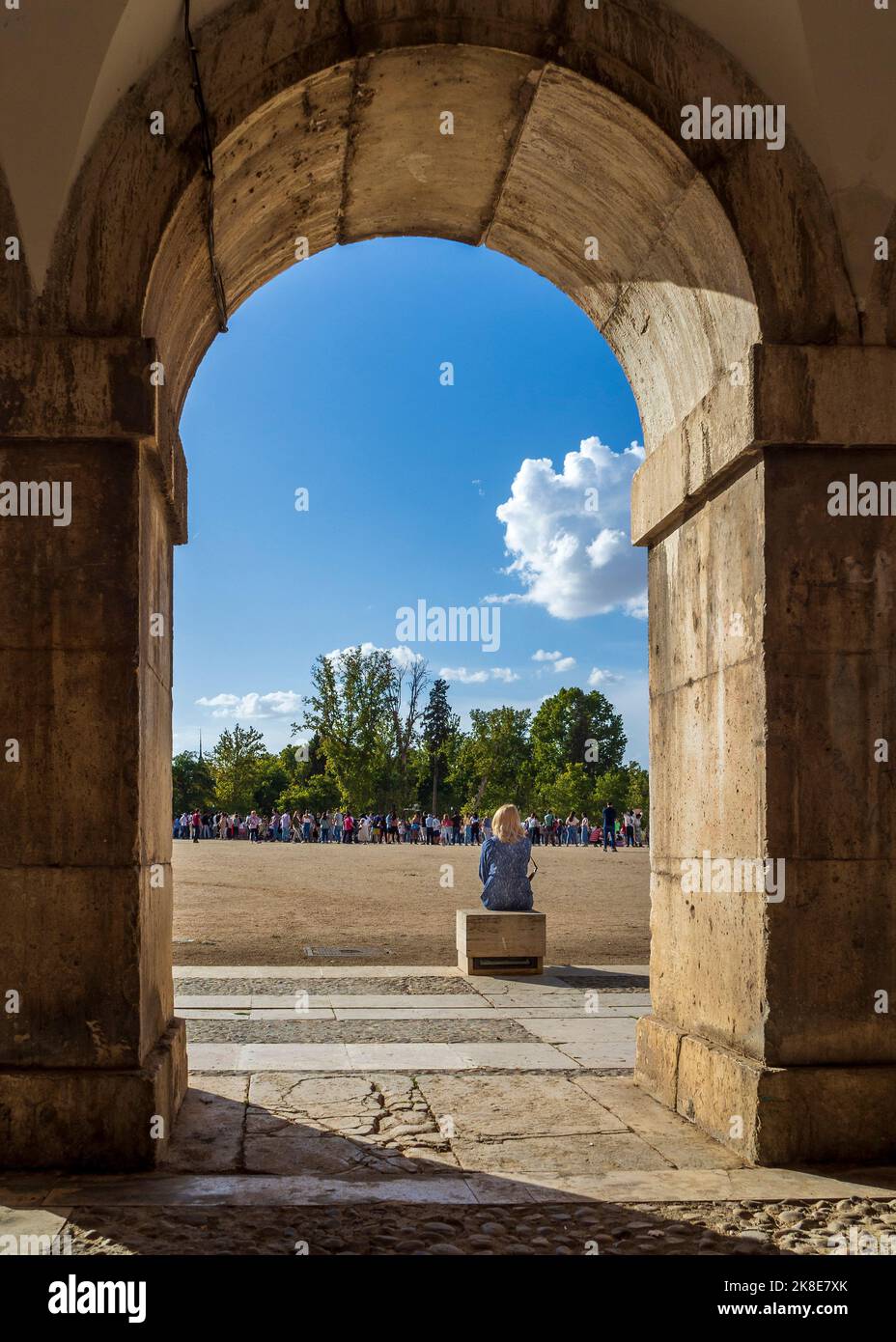 A woman seated in the stone arches of the Aranjuez palace Stock Photo ...