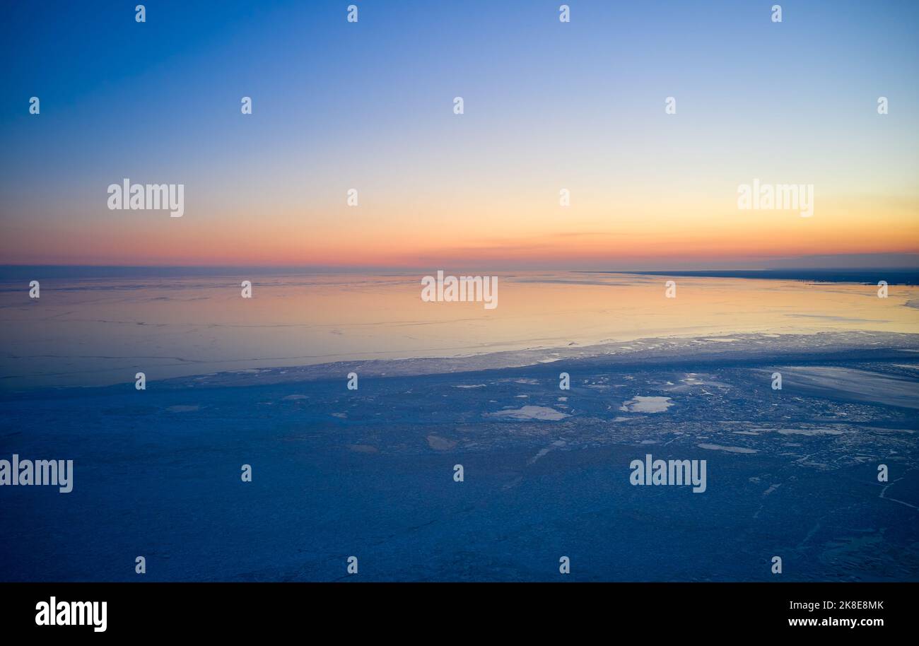 Aerial view of sunset over the frozen sea. Winter landscape on seashore ...