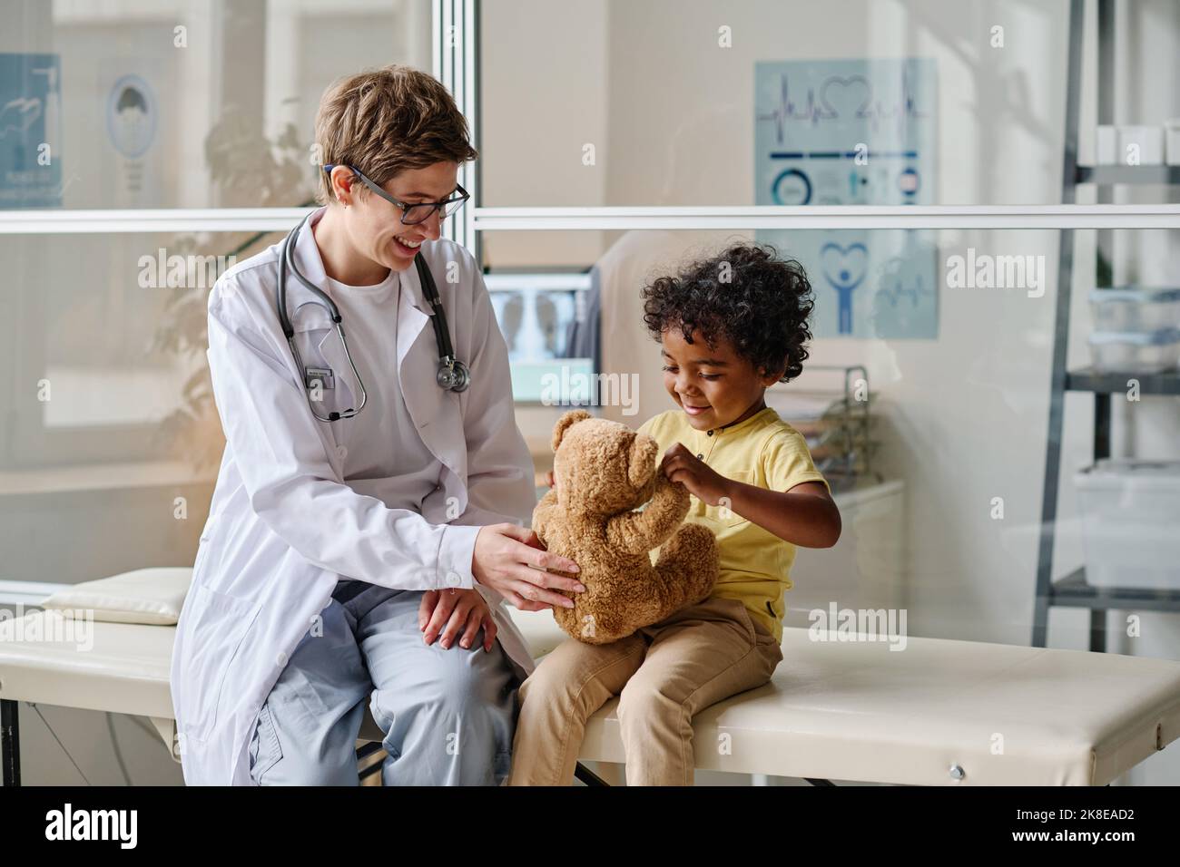 Pediatrist playing with toy with her little patient during medical exam ...