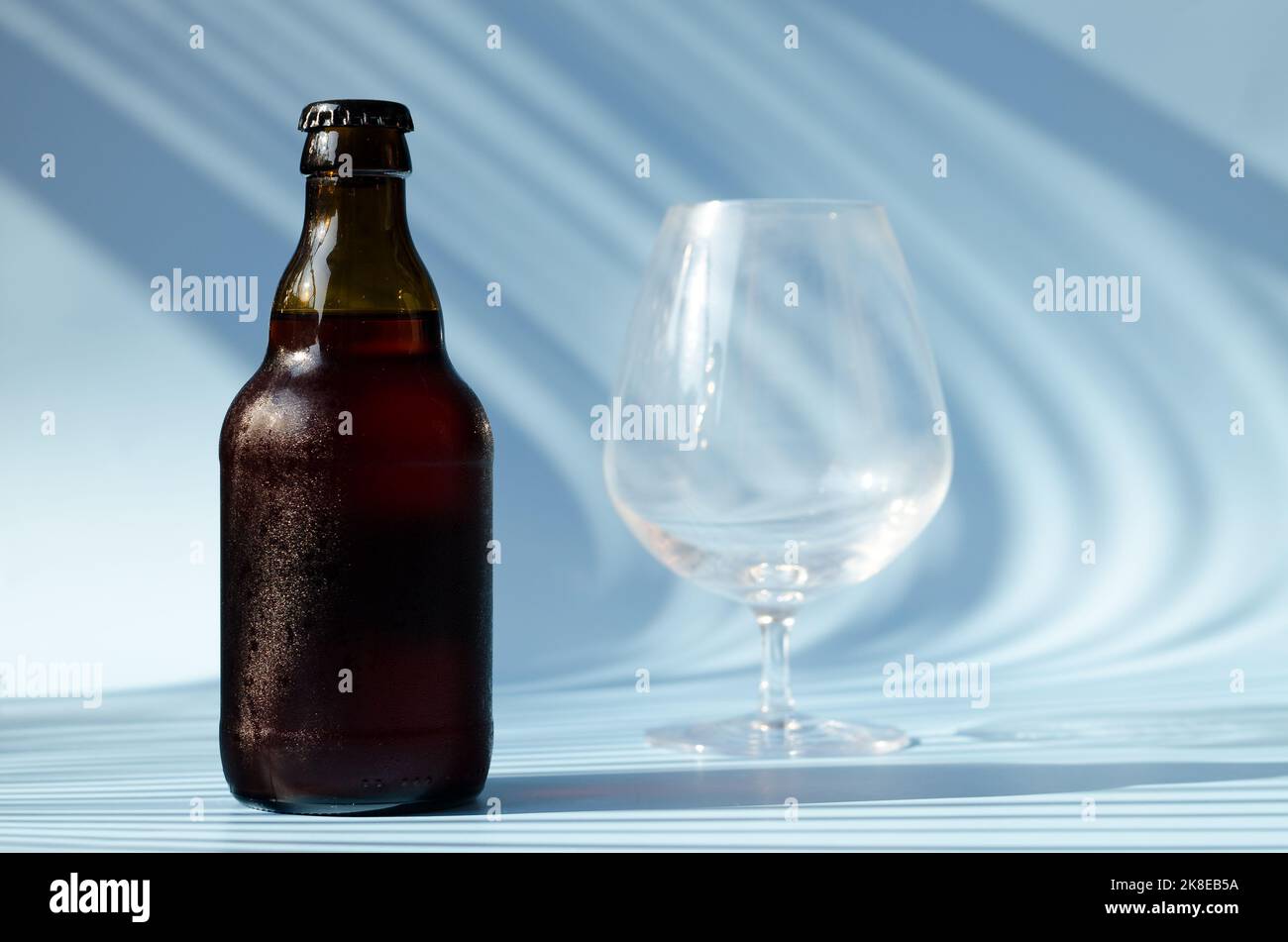 Top view of glass brown beer bottle, glass of beer against blue ...