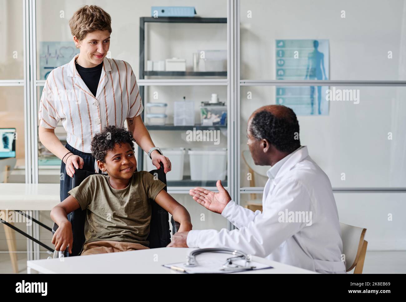African doctor discussing rehabilitation with little patient in ...