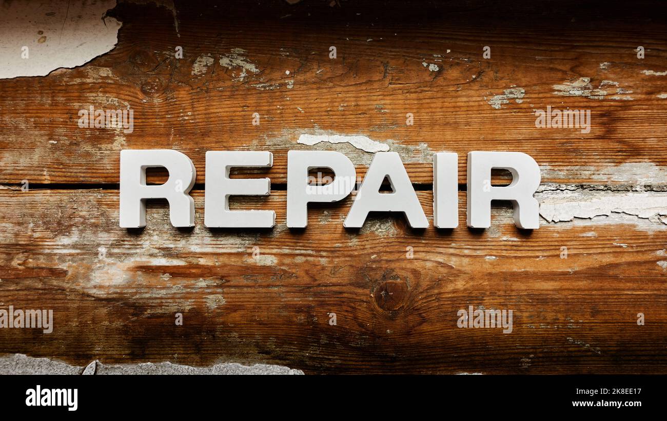 Repair - Single word on old worn wooden planks Stock Photo - Alamy