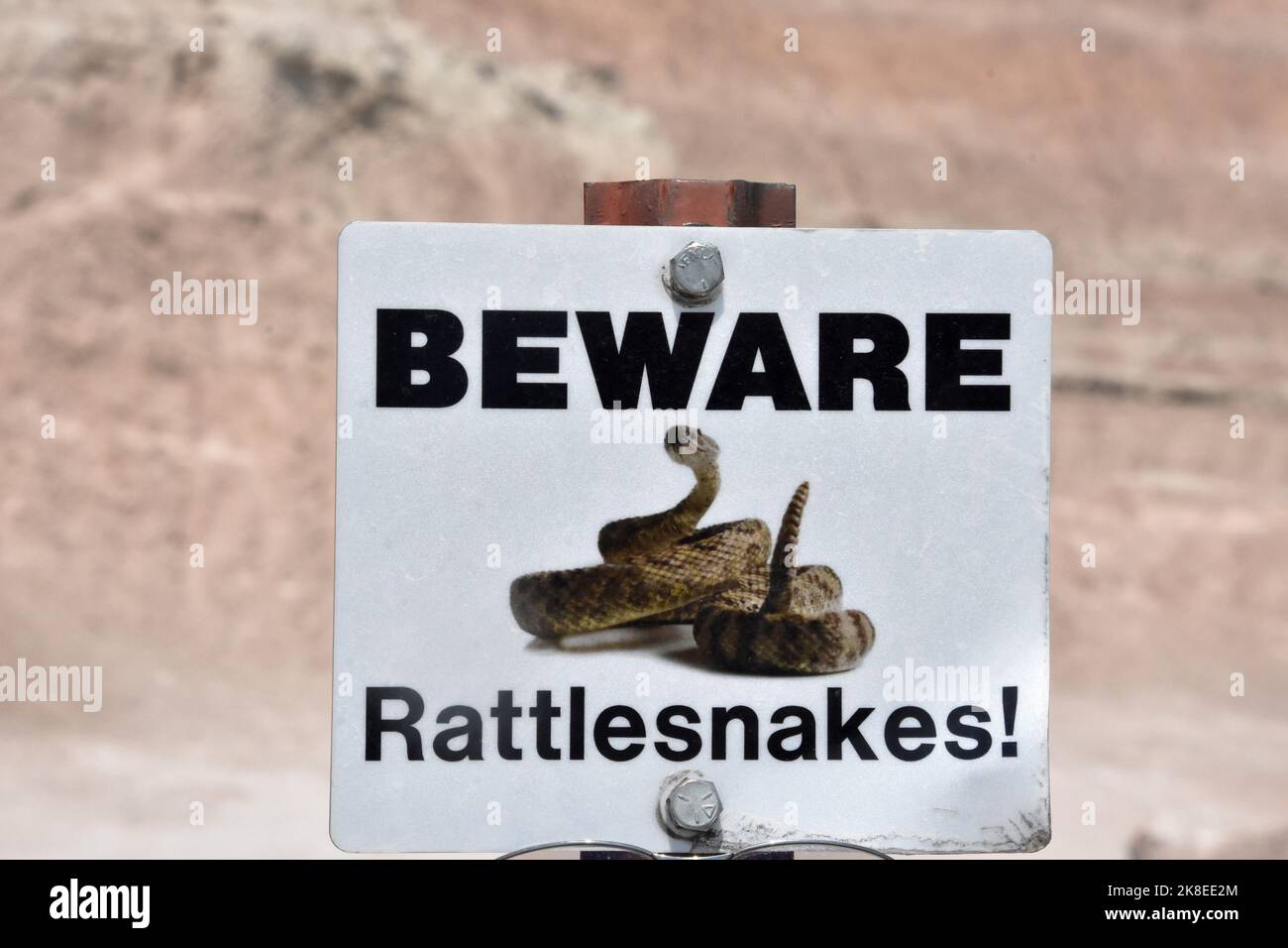 White beware of rattlesnakes sign on a hiking trail in the badlands ...
