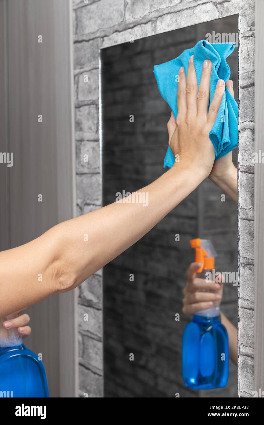 woman wiping a mirror with a rag. man washing glass. House cleaning ...