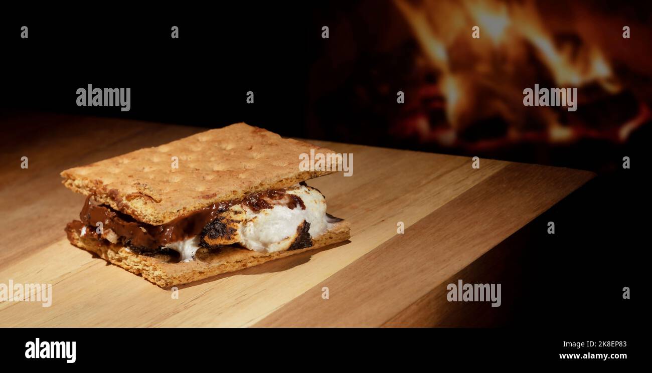 Special smore treat for the family with fire behind Stock Photo - Alamy