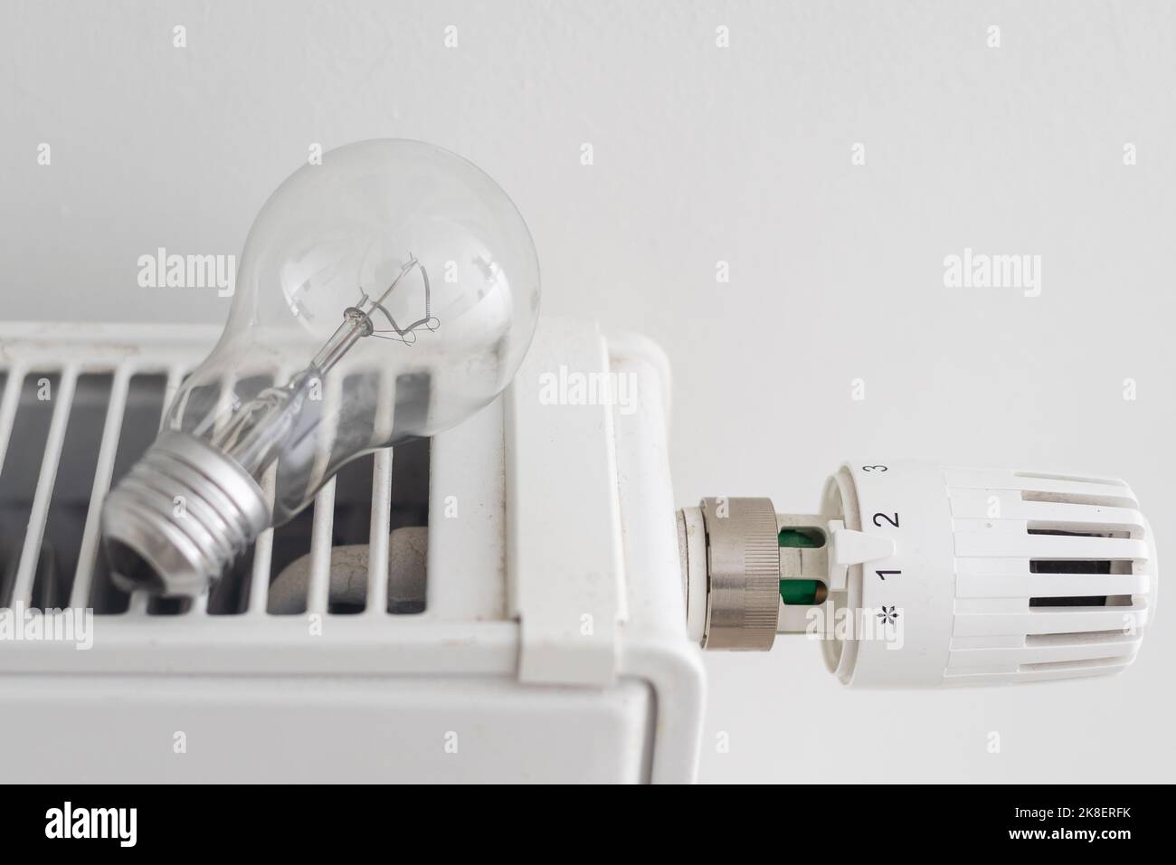 heating, energy crisis and consumption concept - light bulb on radiator ...