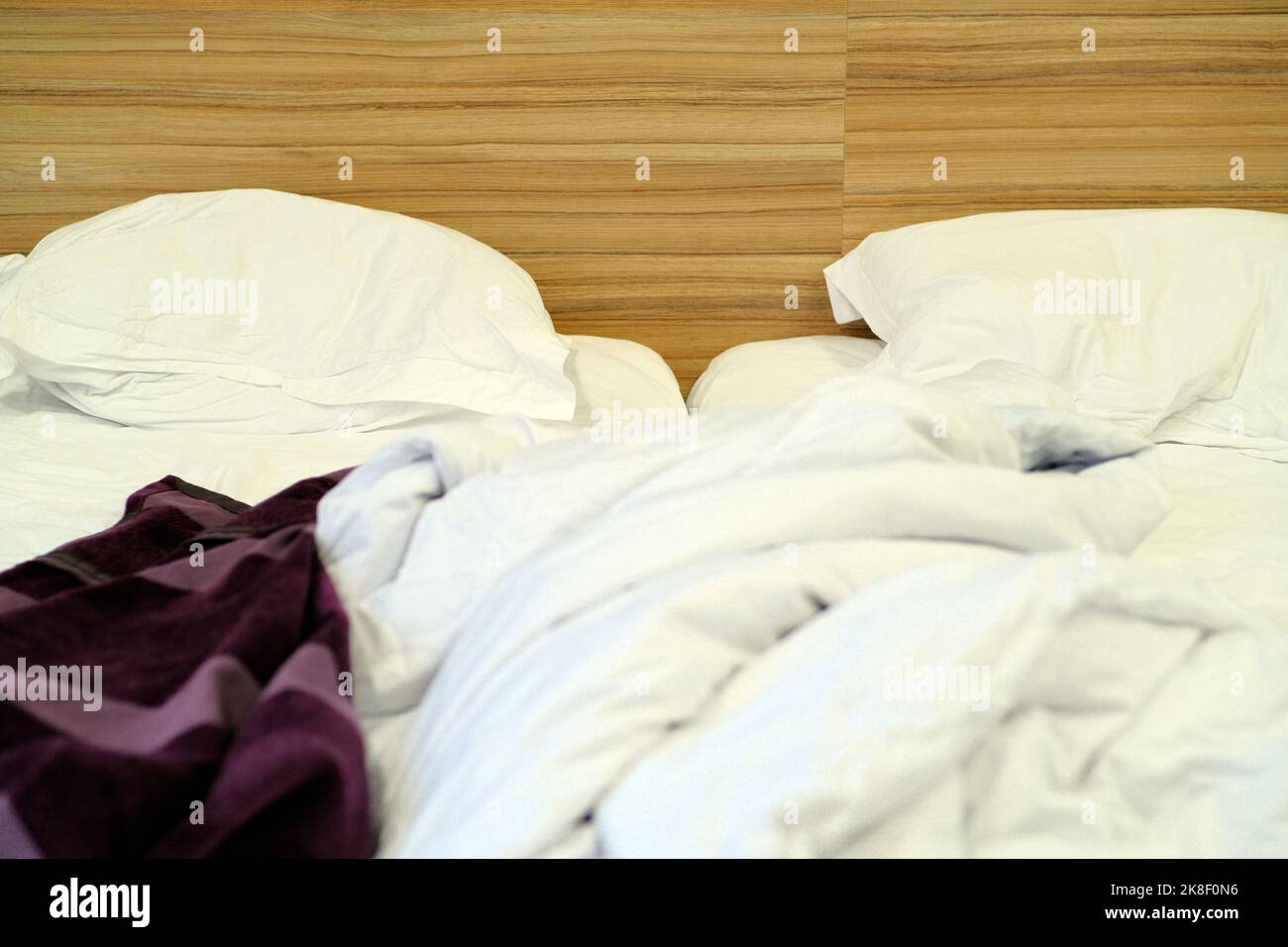 Bed with pillows and crumpled blanket. Crumpled blanket and pillows on ...