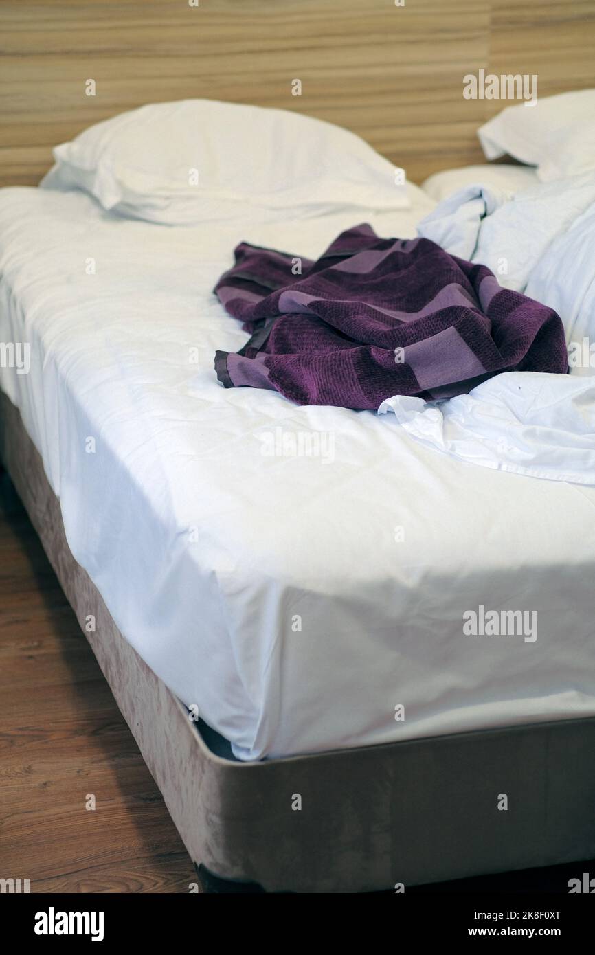 Bed with pillows and crumpled blanket. Crumpled blanket and pillows on ...
