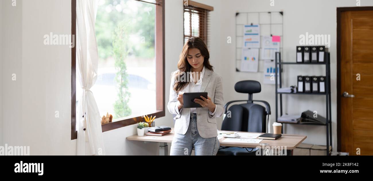 Woman accountant using calculator and digital tablet computer in office ...