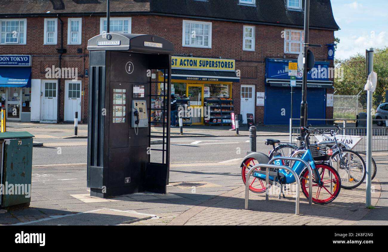 An old-school telephone box near shops in West Acton, London Stock ...