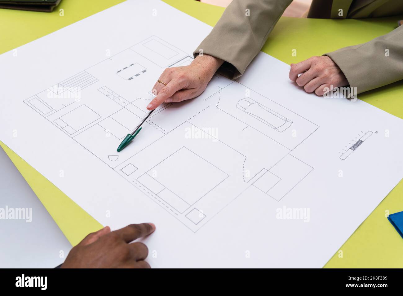 Architect explaining floor plan on table Stock Photo - Alamy