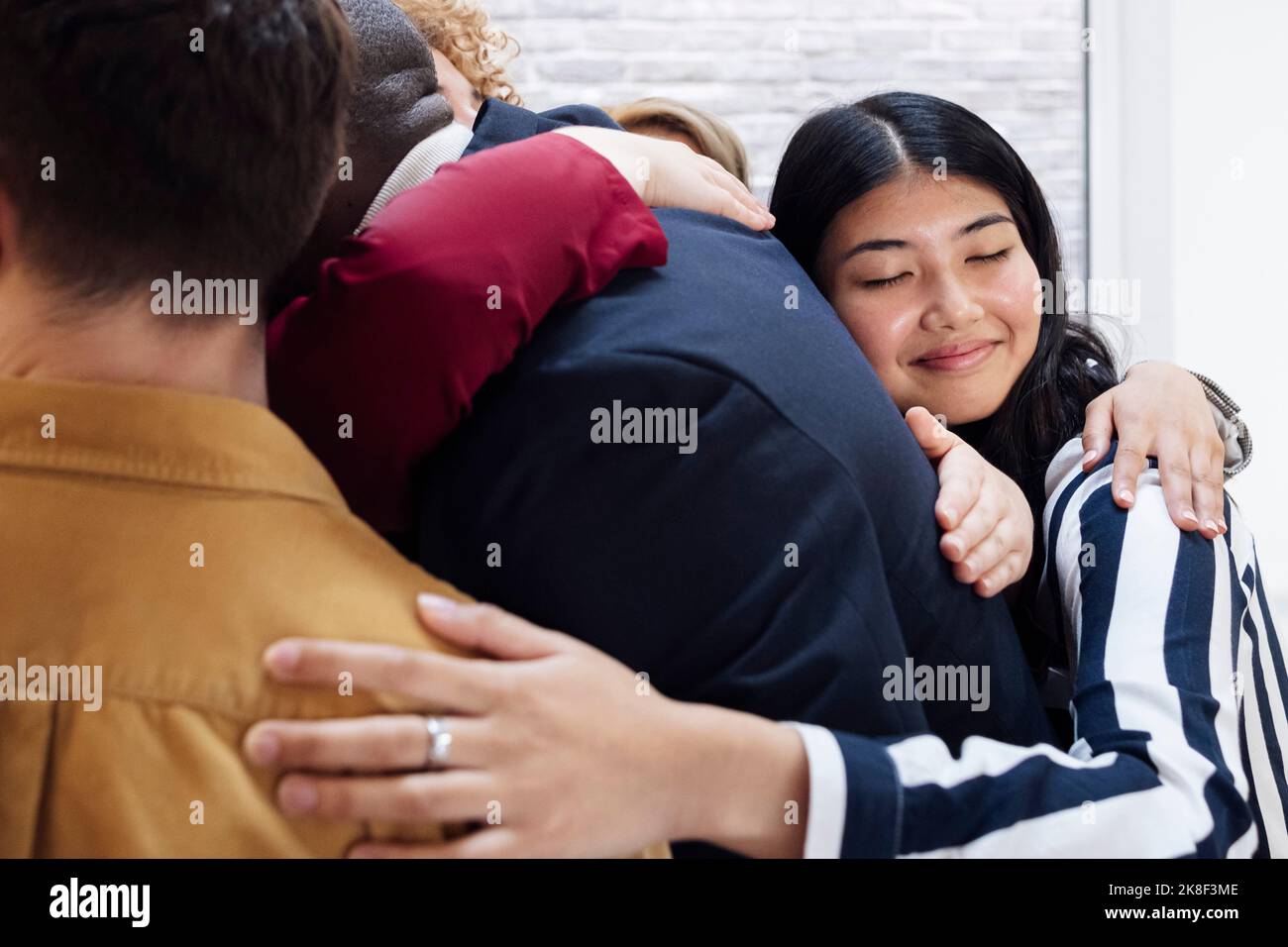 Happy business people hugging in office Stock Photo - Alamy