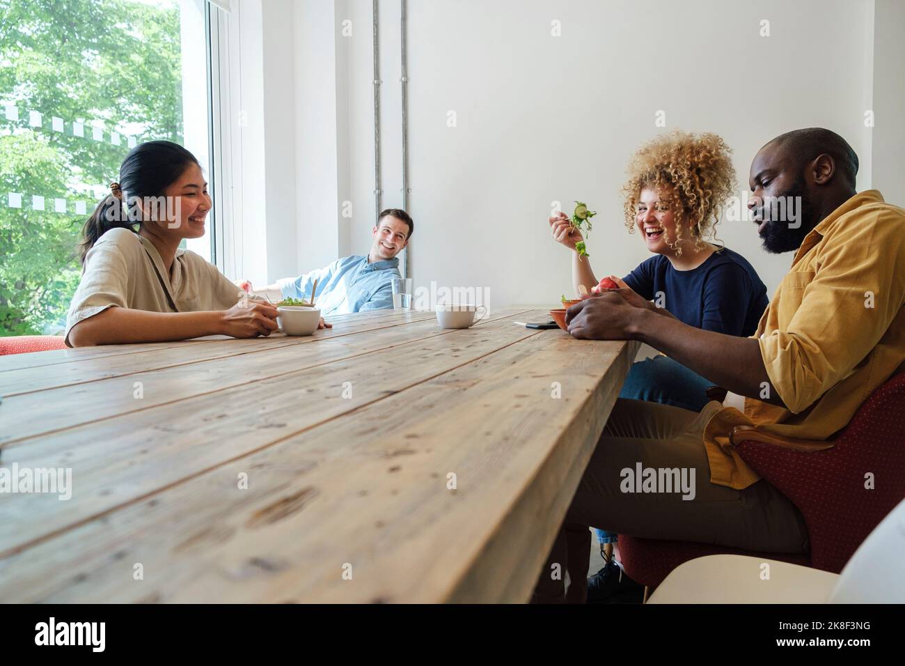 Business people having healthy lunch together in staff room at modern ...