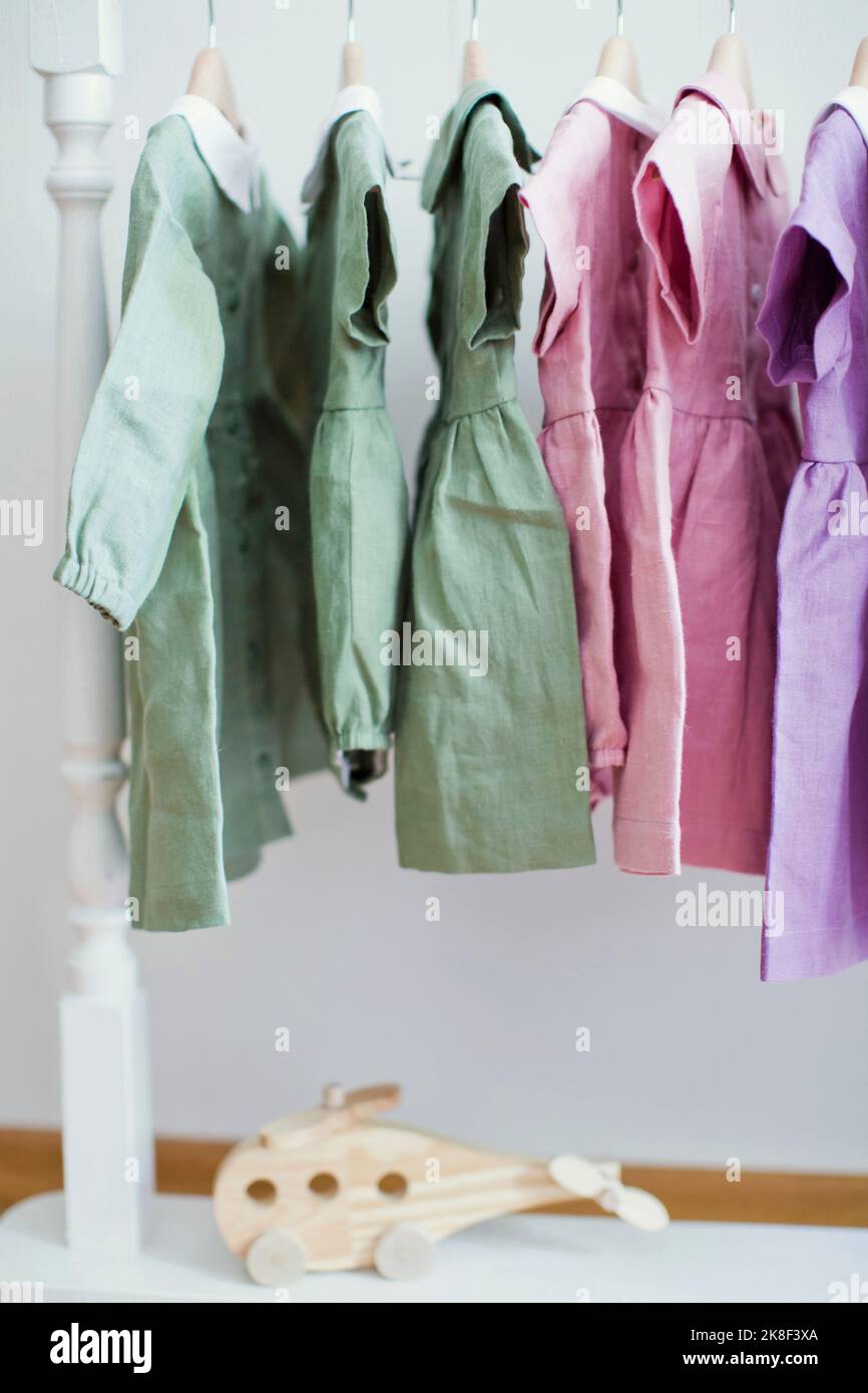 Colorful dresses hanging on rack in front of wall Stock Photo - Alamy