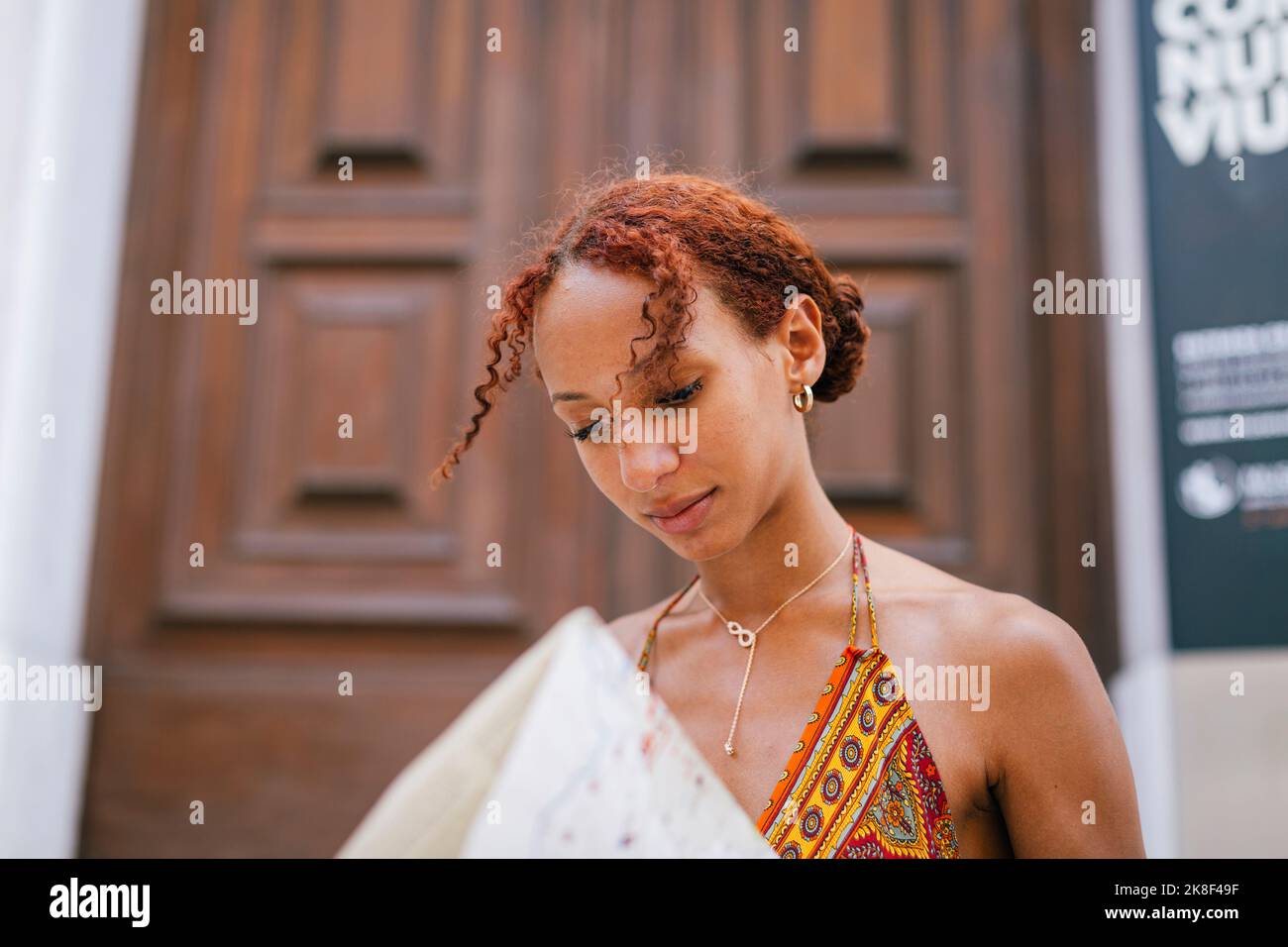 Young woman with curly hair reading map Stock Photo - Alamy