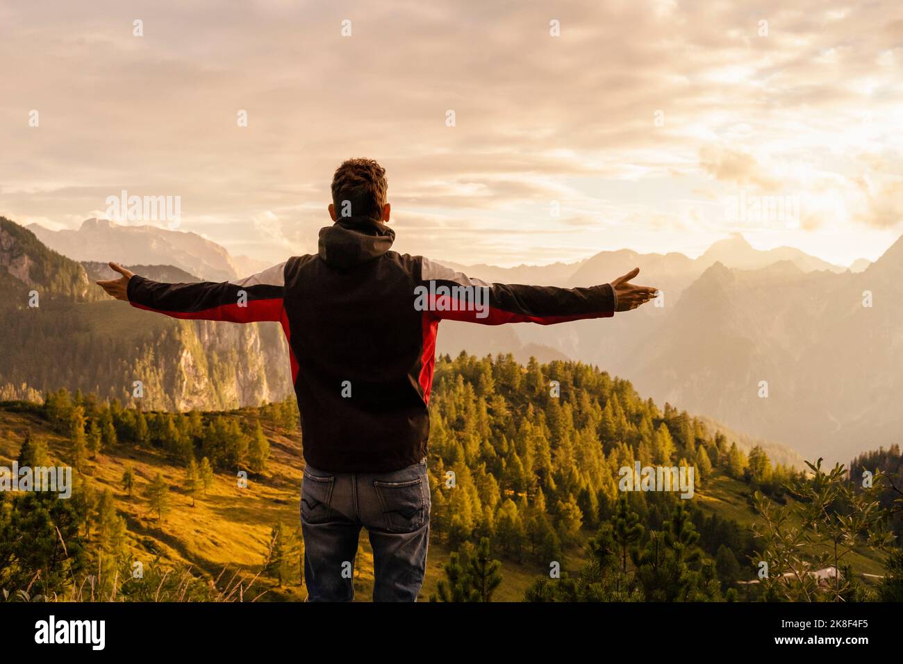 Man standing with arms outstretched on mountain Stock Photo - Alamy