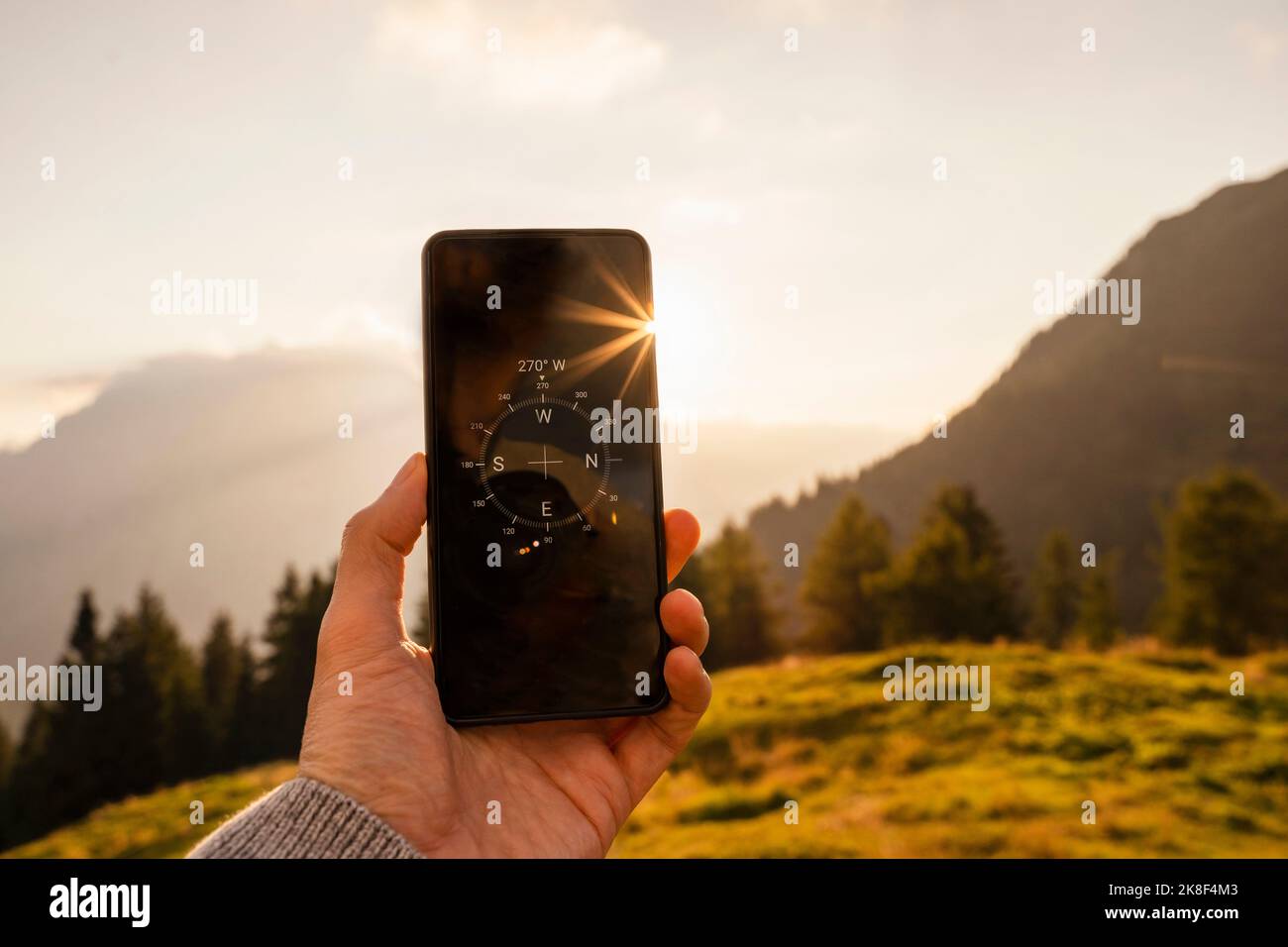 Hand of man showing compass on mobile phone Stock Photo - Alamy