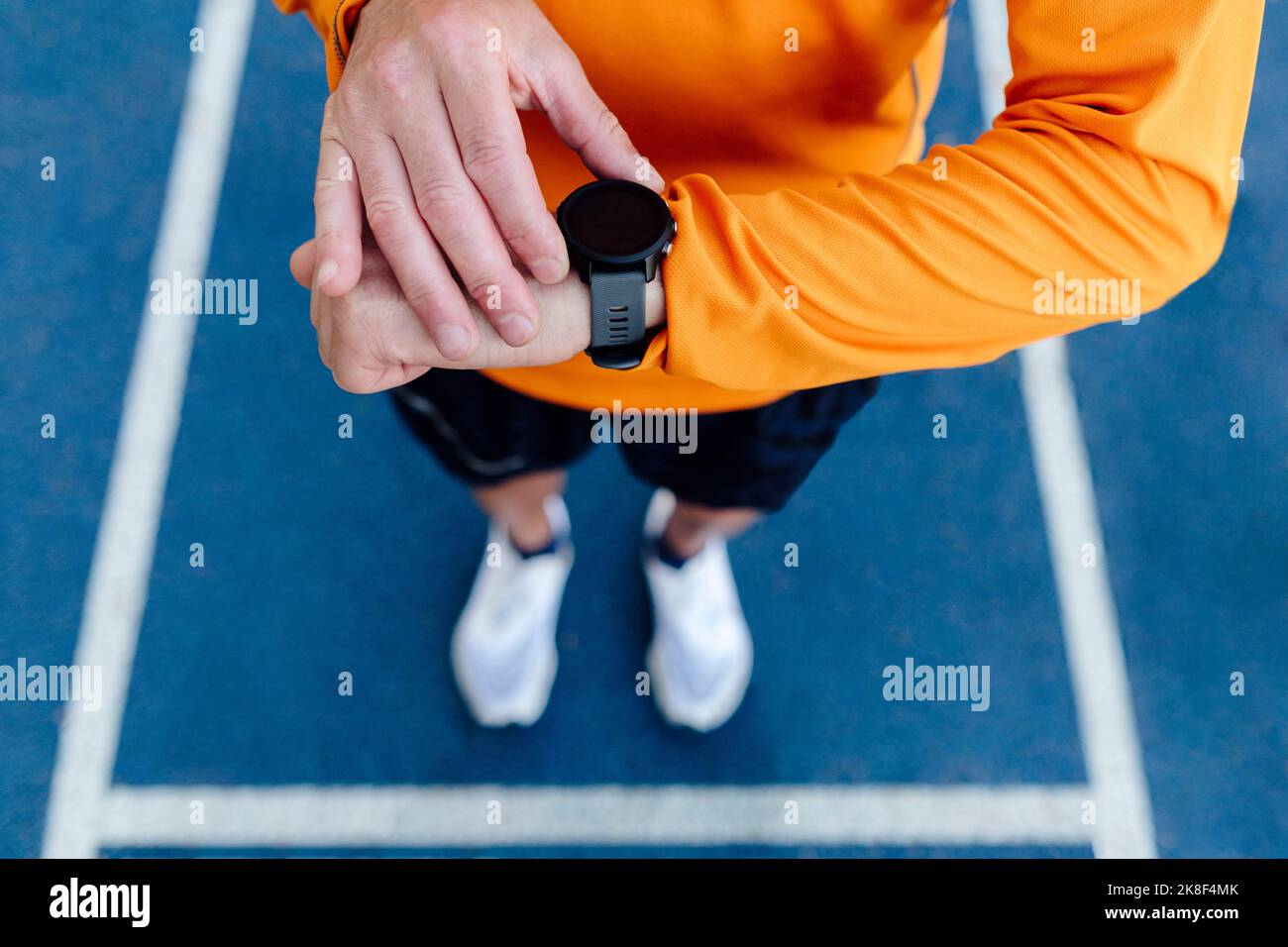 Hand of sportsman with smart watch on running track Stock Photo - Alamy