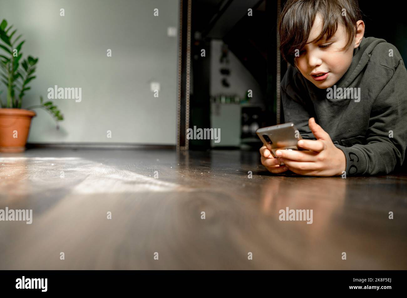 Boy using mobile phone lying hi-res stock photography and images - Alamy