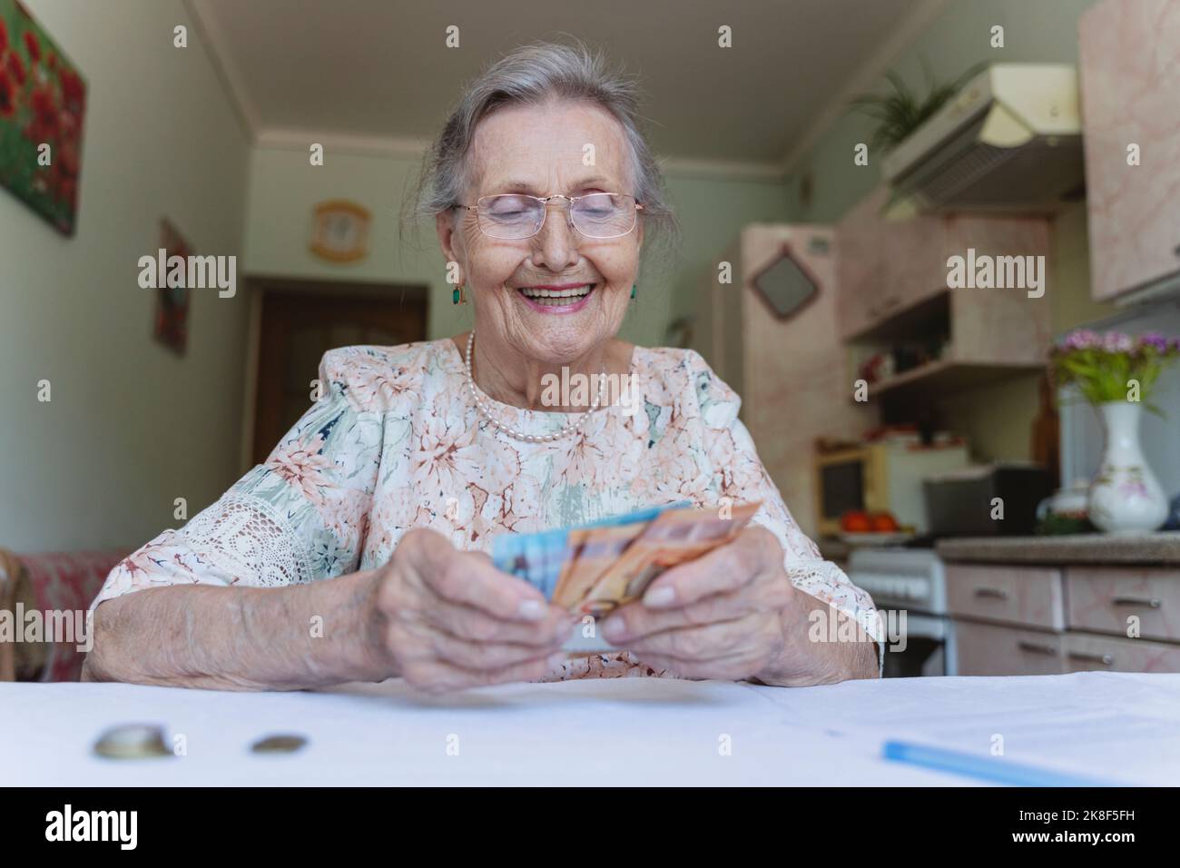 Happy senior woman counting paper currency at home Stock Photo - Alamy