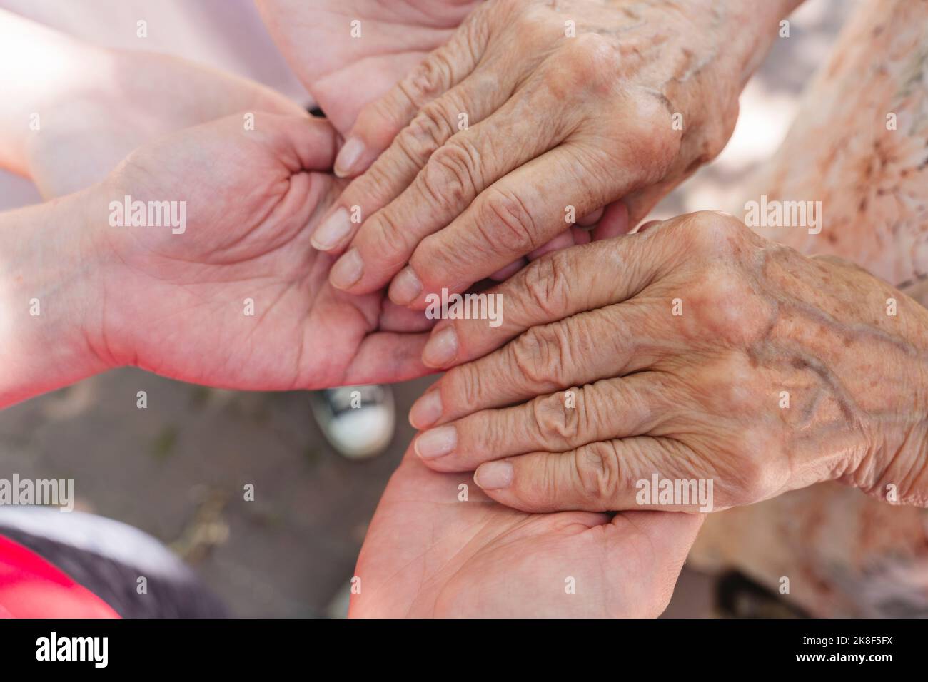 Elderly woman holding hands of granddaughter and great granddaughter ...