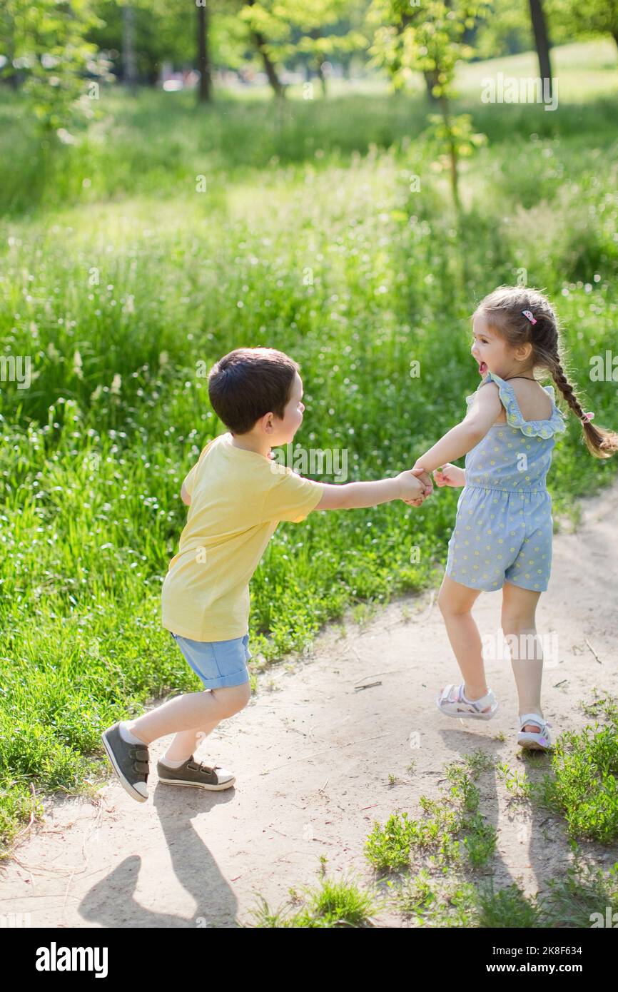 Happy siblings playing together at park on sunny day Stock Photo - Alamy