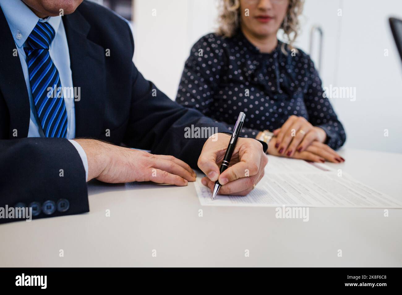 Mature businessman doing signature on document at desk Stock Photo - Alamy