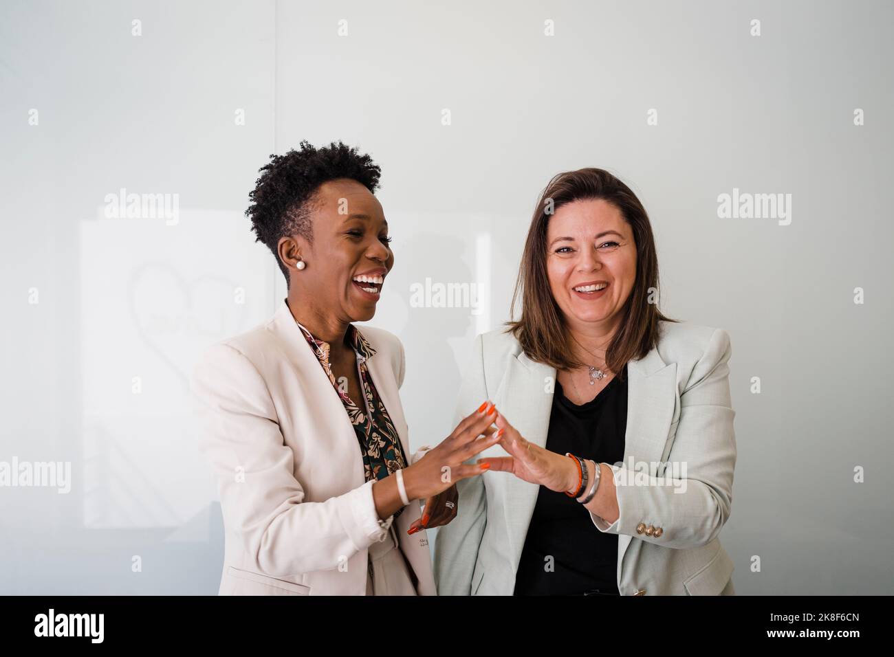 Happy business colleagues touching hands of each other in front of ...