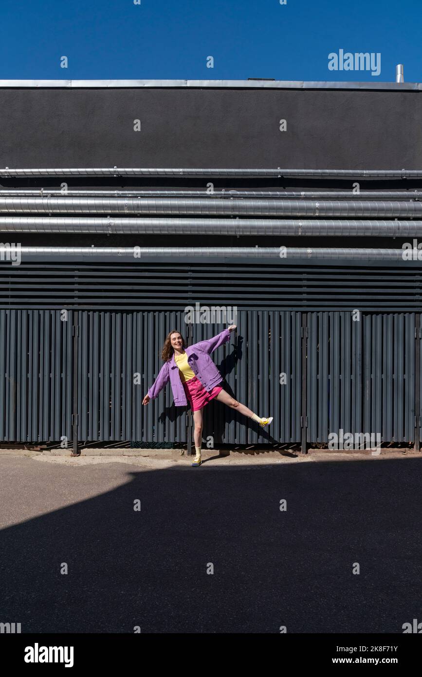 Woman balancing on one leg in front of wall Stock Photo - Alamy