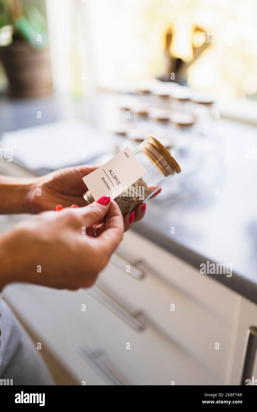 Hands of woman labeling glass jar at kitchen counter Stock Photo - Alamy