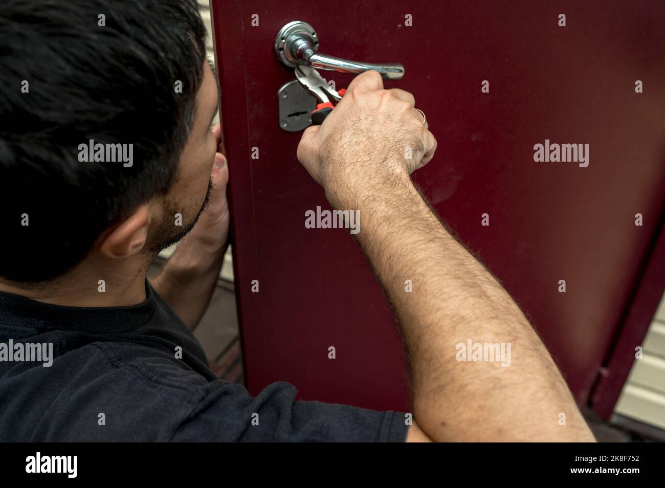 Man repairing lock of door Stock Photo - Alamy