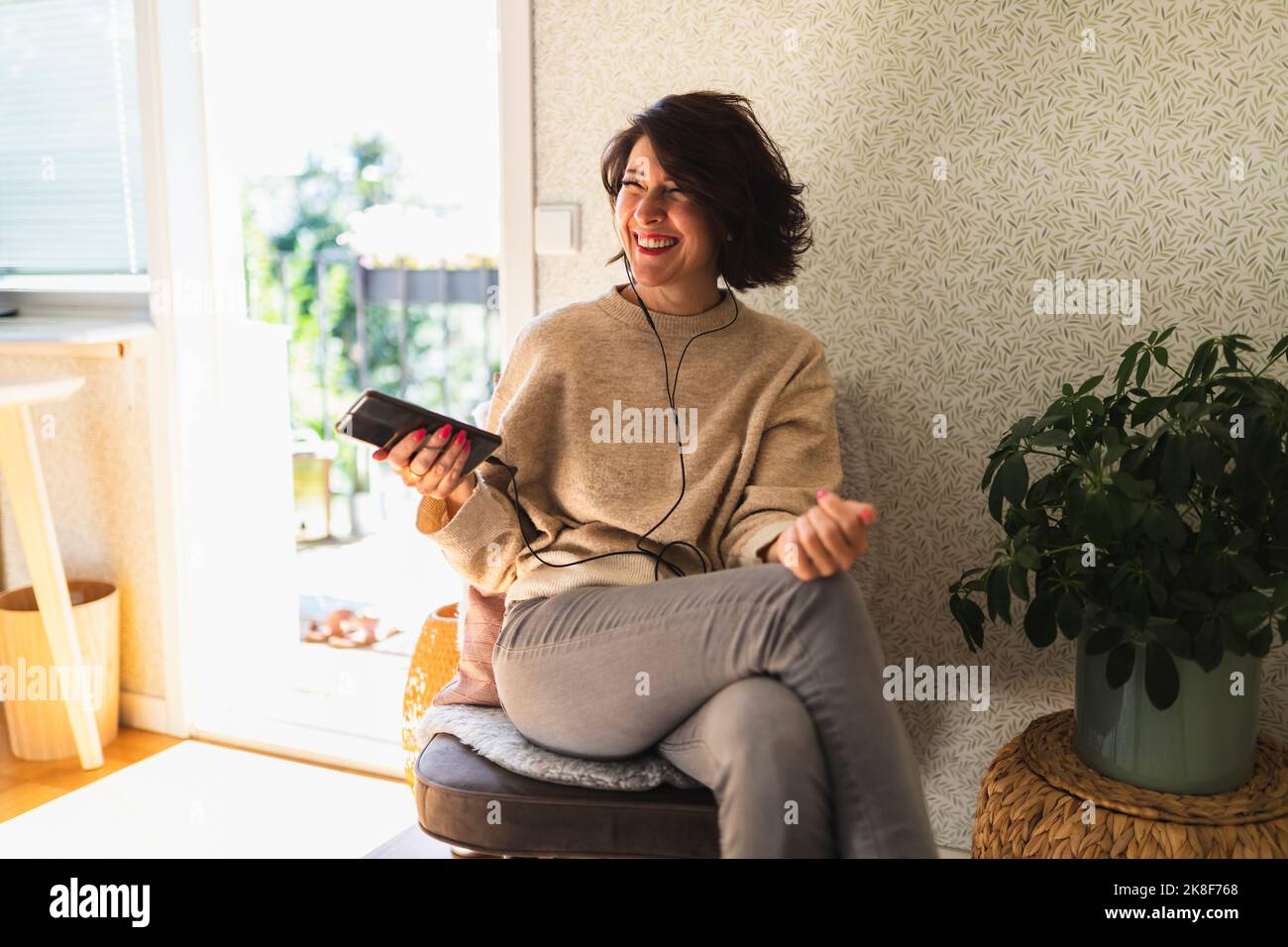 Woman sitting on chair holding mobile phone hi-res stock photography ...