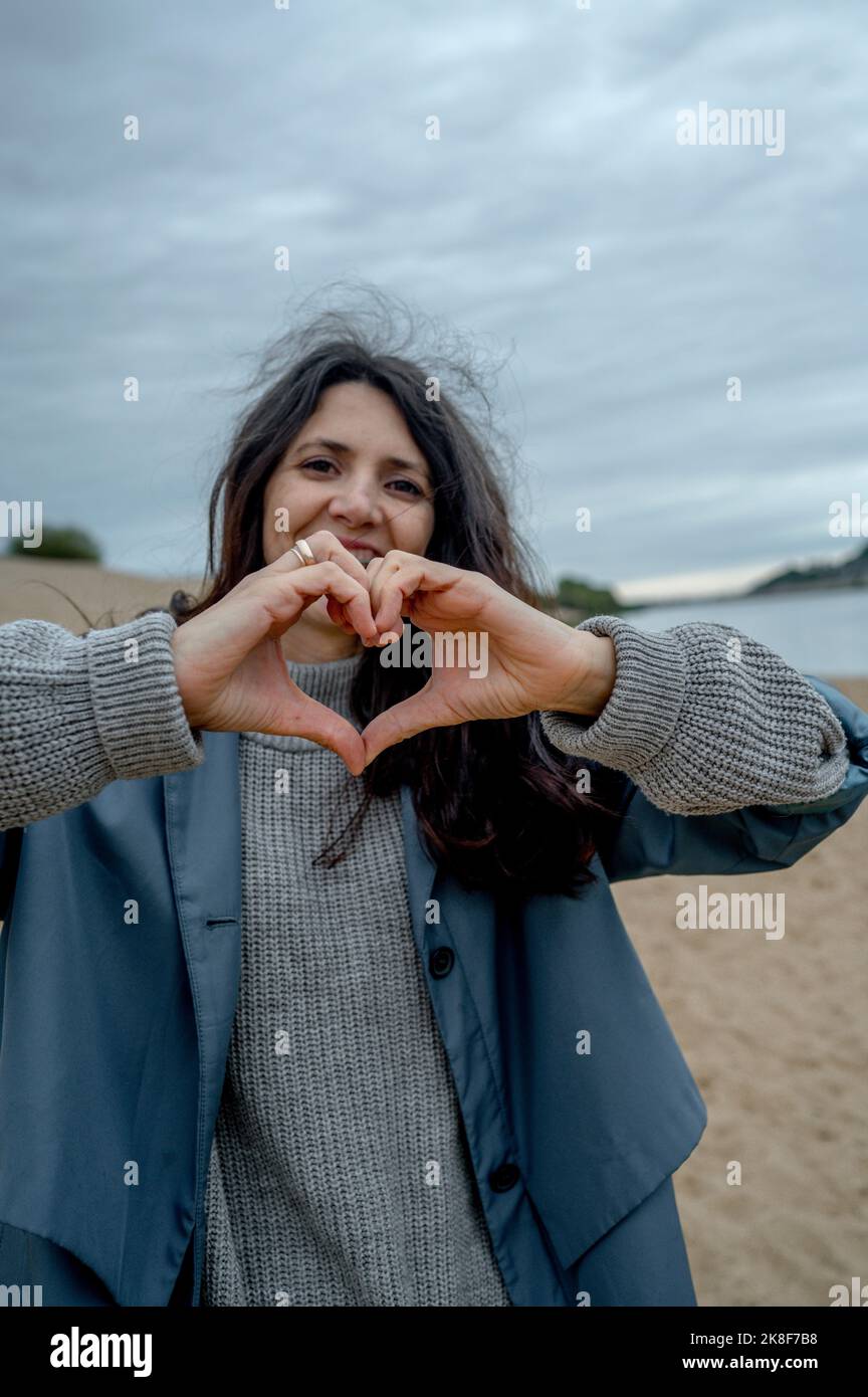 Woman smiling making heart shape hi-res stock photography and images ...