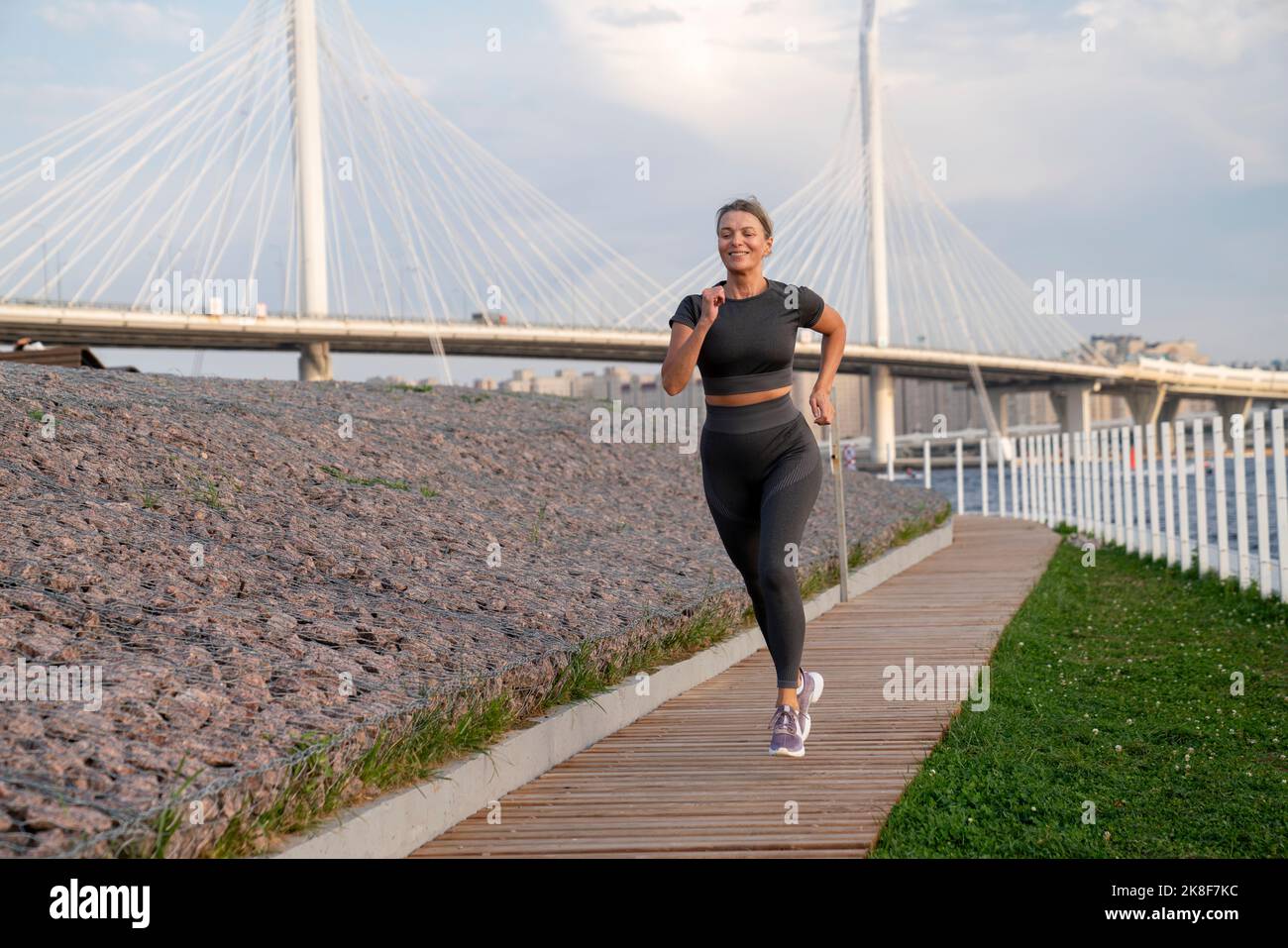 Woman running on path smiling hi-res stock photography and images - Alamy