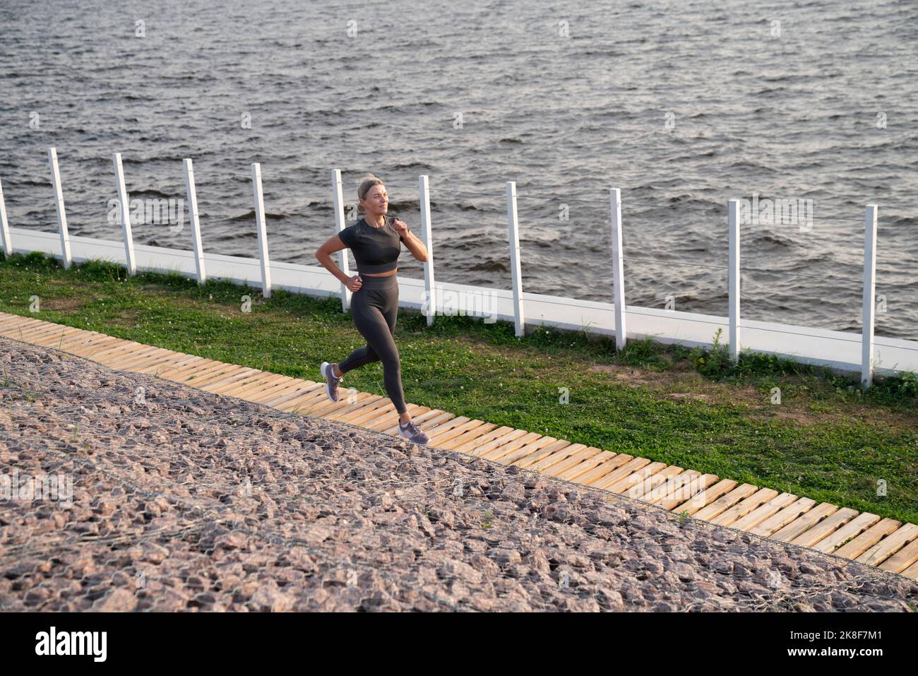 Woman running on path smiling hi-res stock photography and images - Alamy