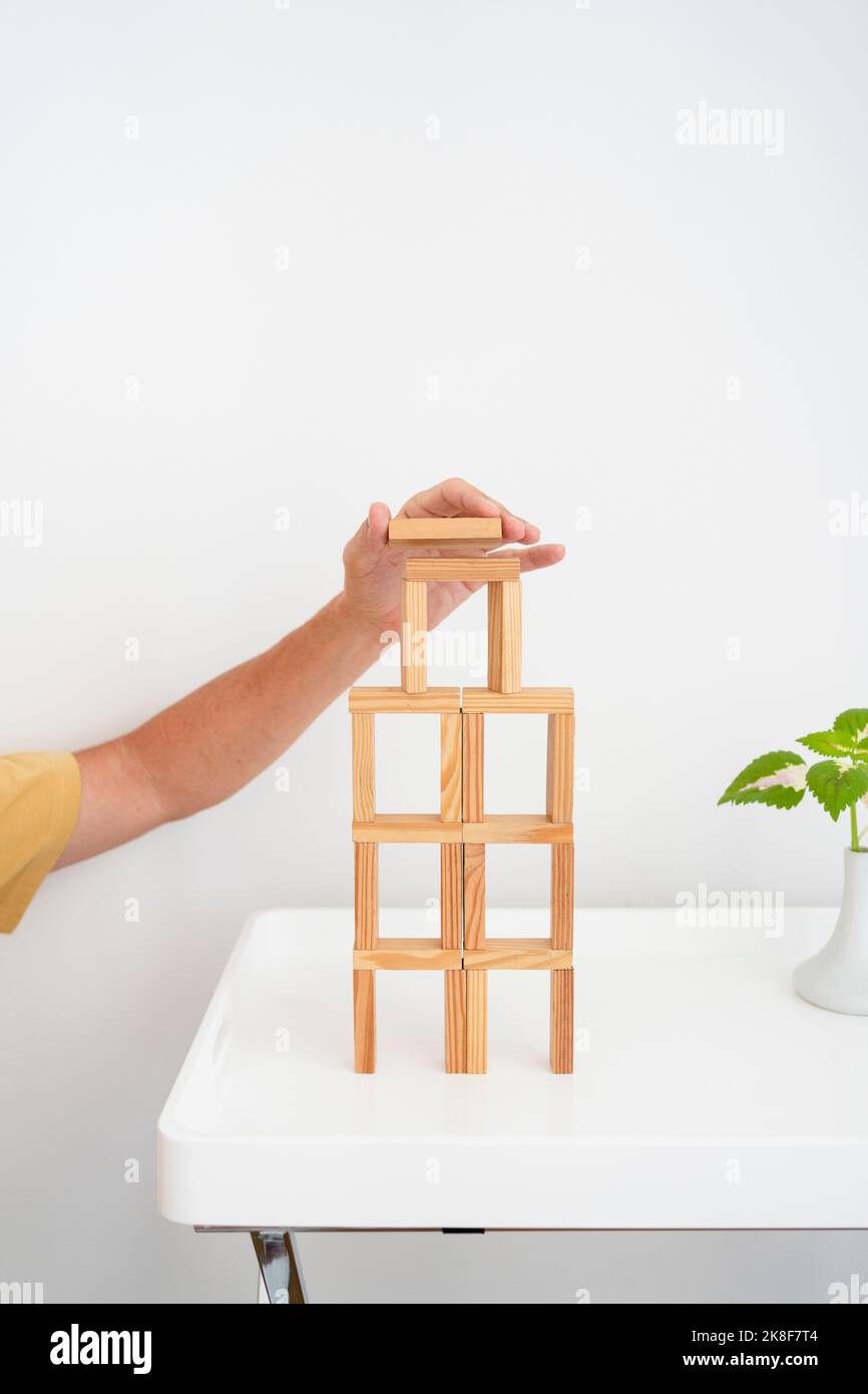 Hand of man building wooden block tower Stock Photo - Alamy