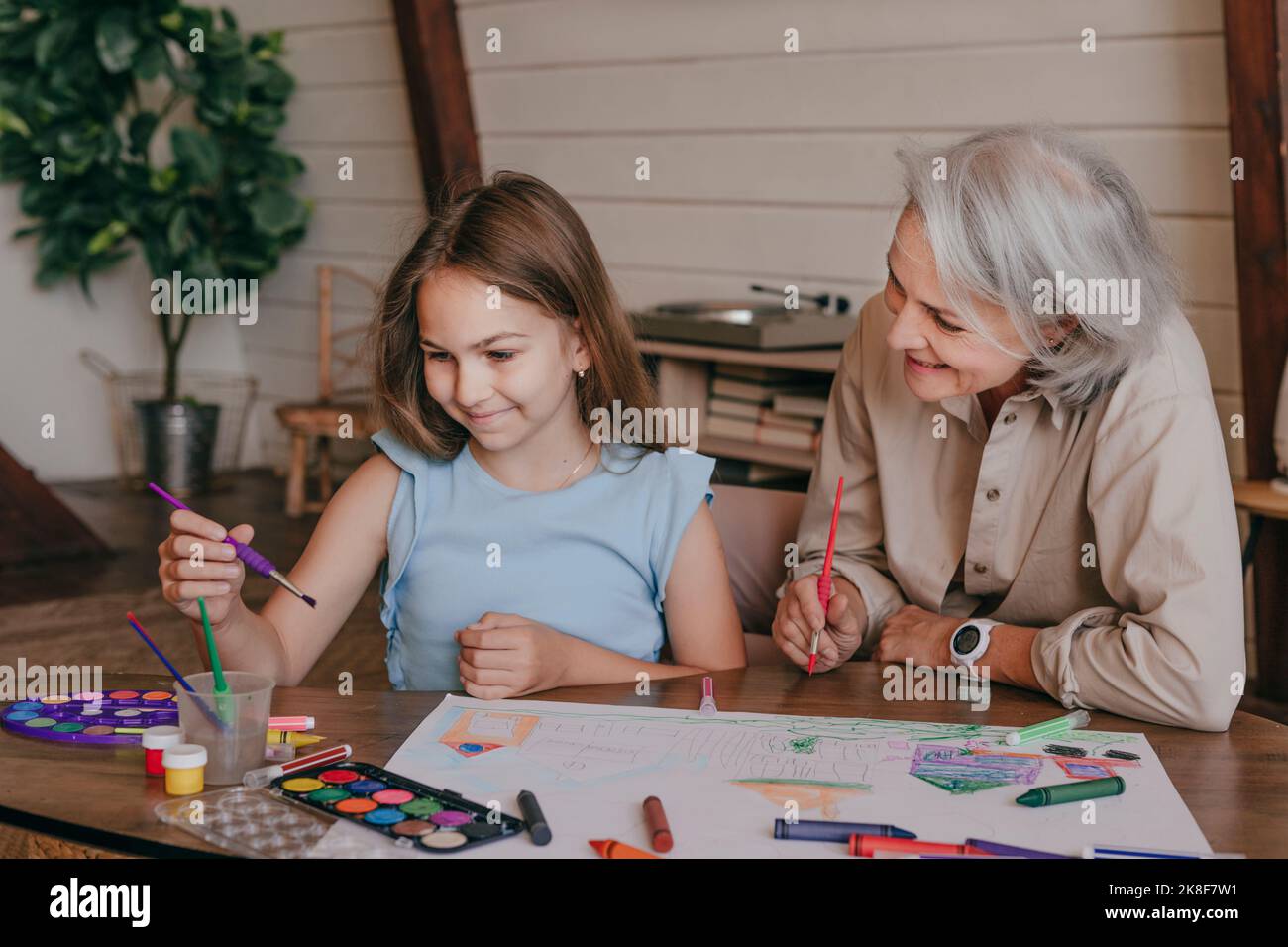 Grandmother helping granddaughter in painting at home Stock Photo - Alamy