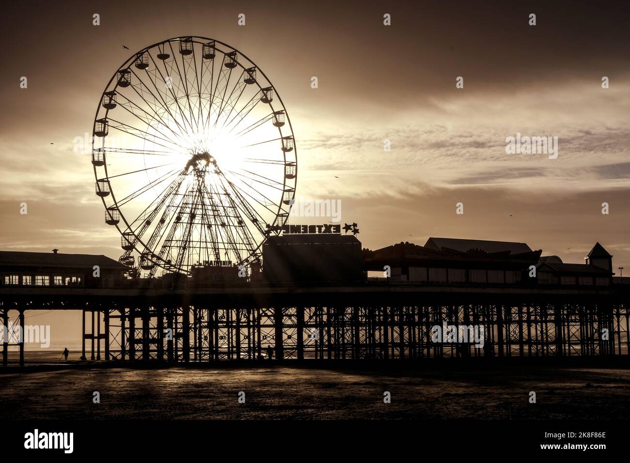 Blackpool Pier with its Ferris wheel and the sunset behind streaming ...