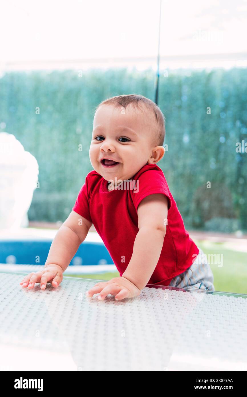 Happy cute baby boy leaning on table Stock Photo - Alamy