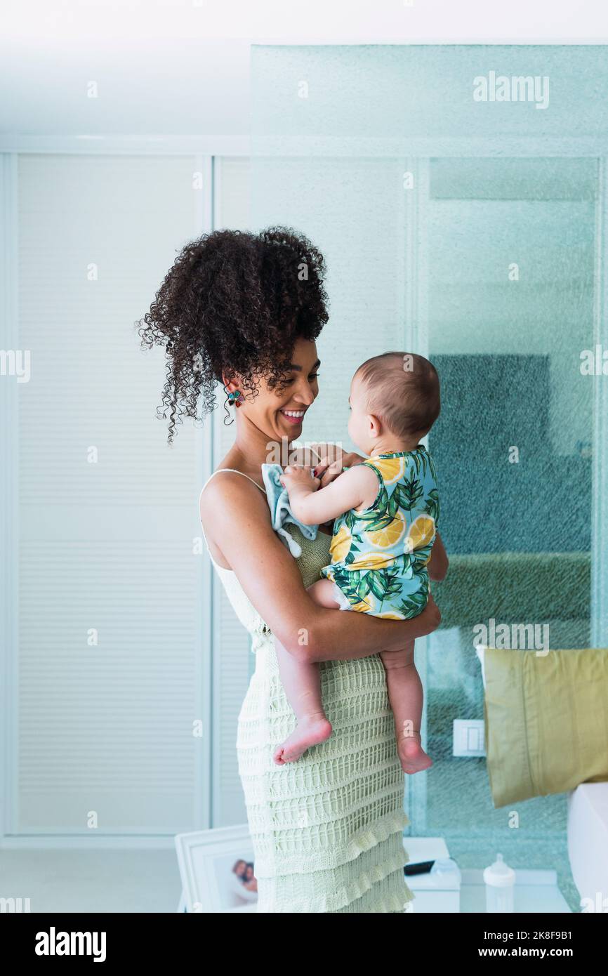 Happy woman carrying baby boy in bedroom at home Stock Photo - Alamy