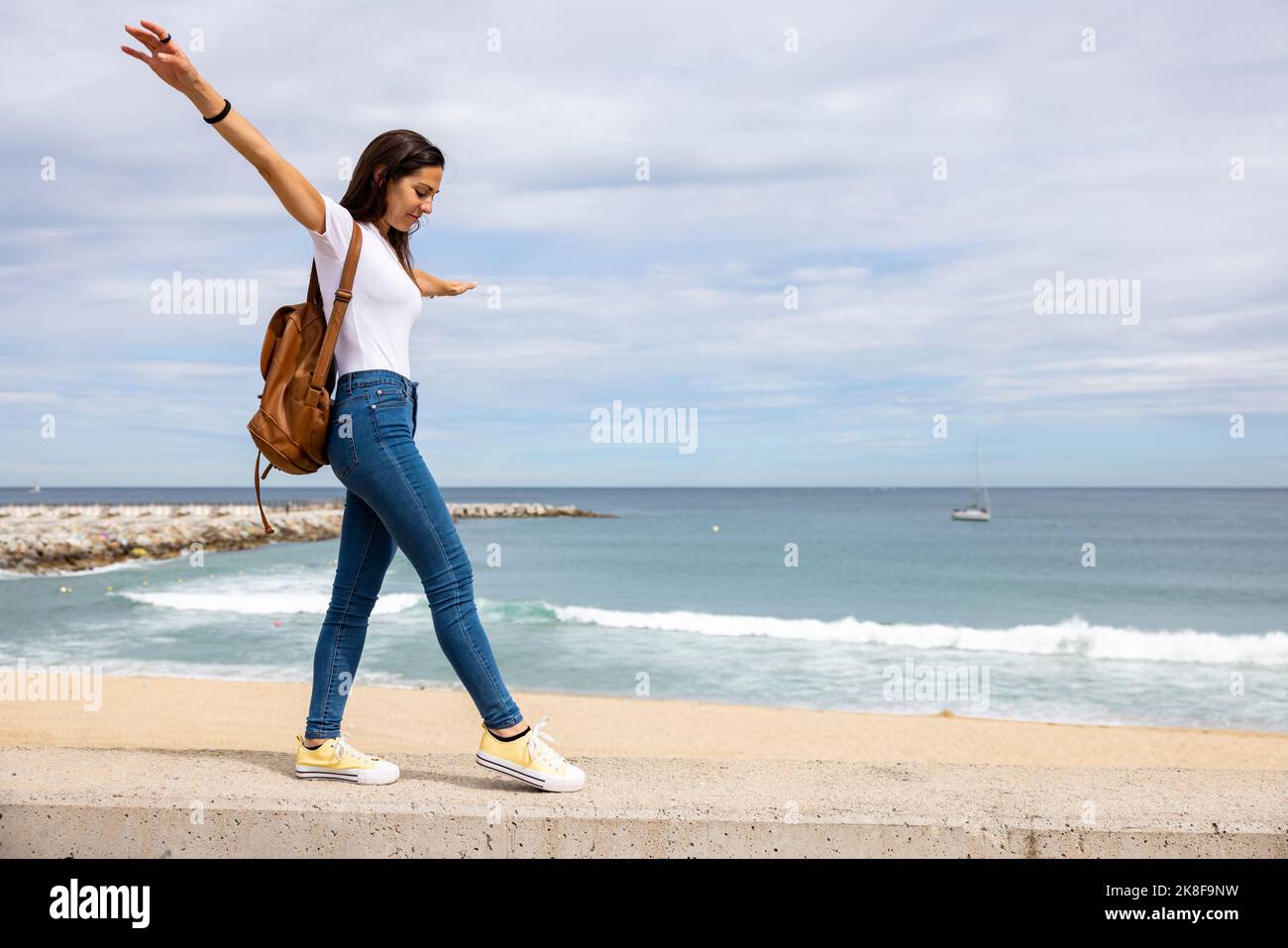 Woman with arms outstretched walking on wall Stock Photo - Alamy