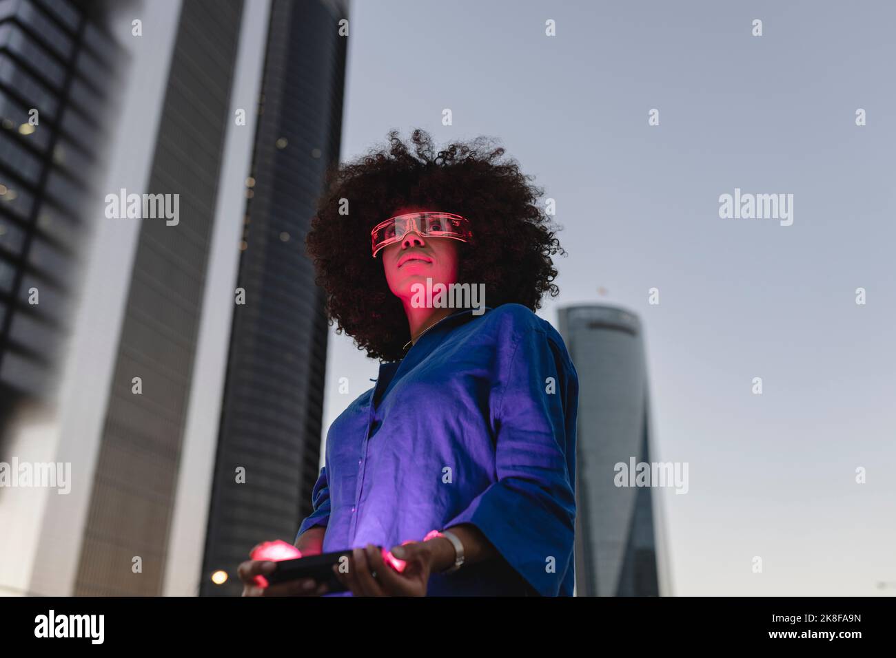 Red light falling on woman face wearing smart glasses in front of ...