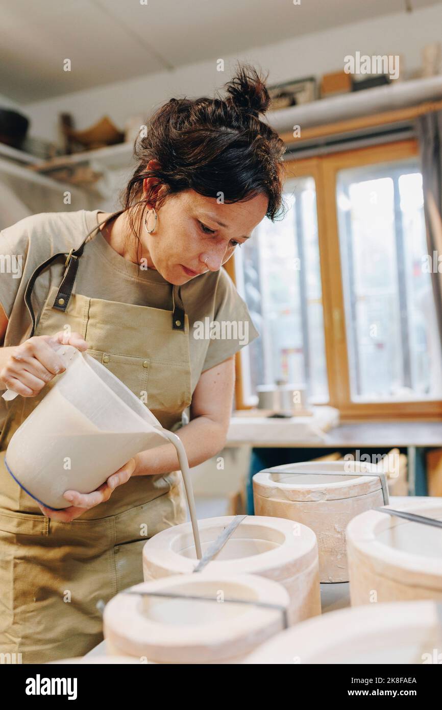 Potter pouring clay in ceramics at workshop Stock Photo - Alamy