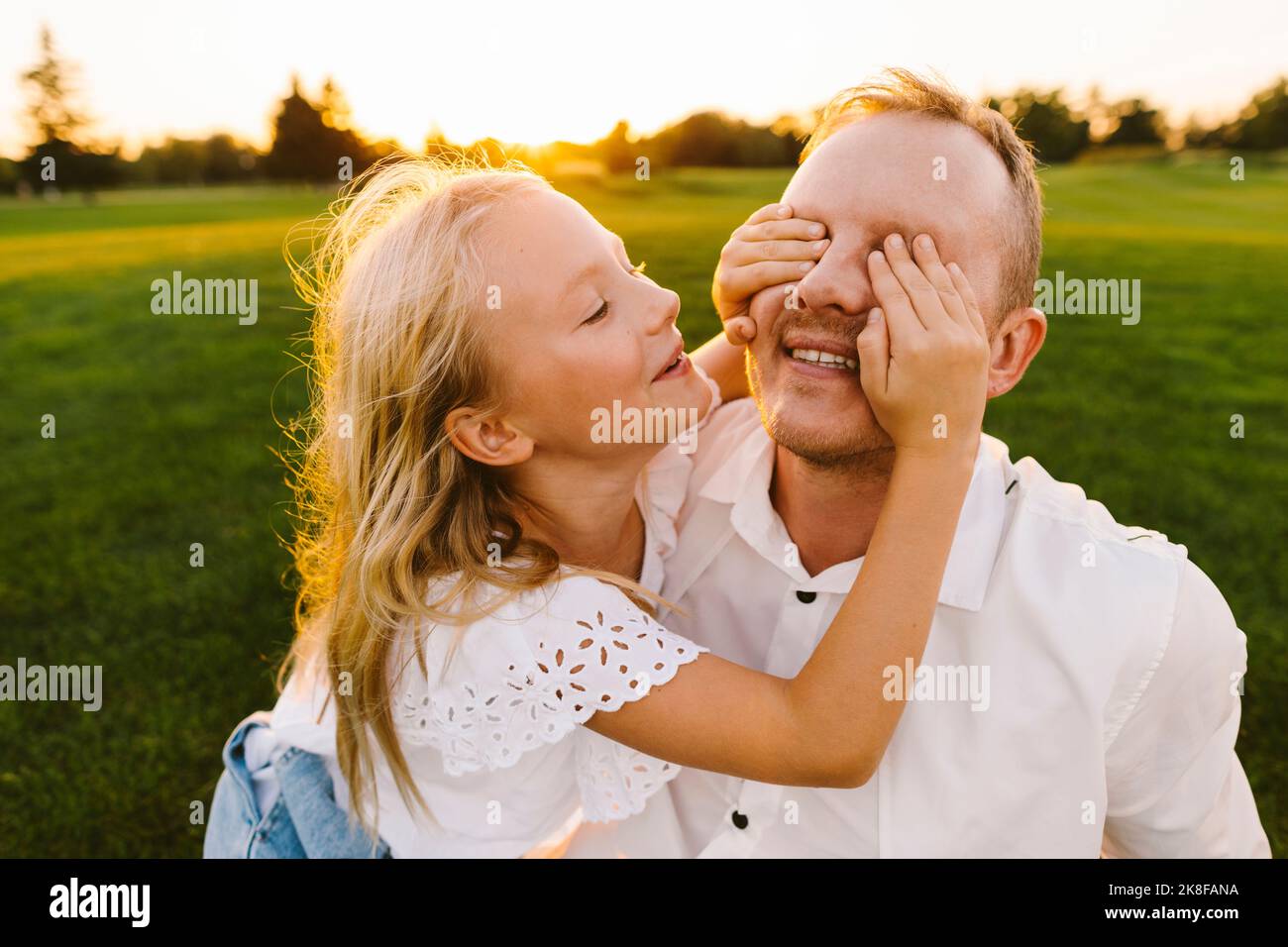 Happy daughter covering father's eyes in park Stock Photo - Alamy