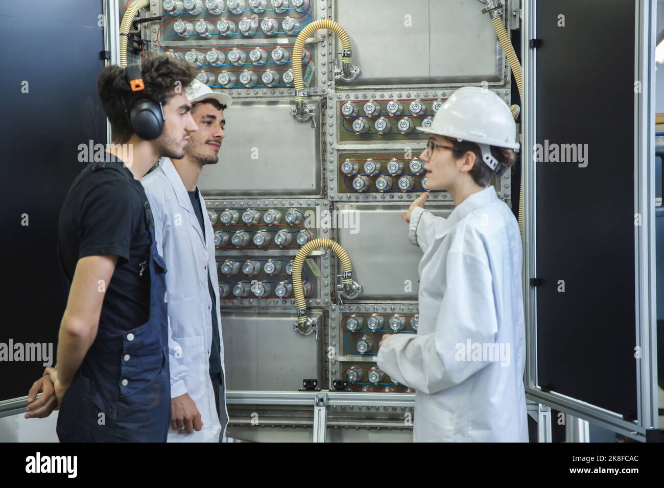 Scientist discussing over quality control with colleagues in factory ...