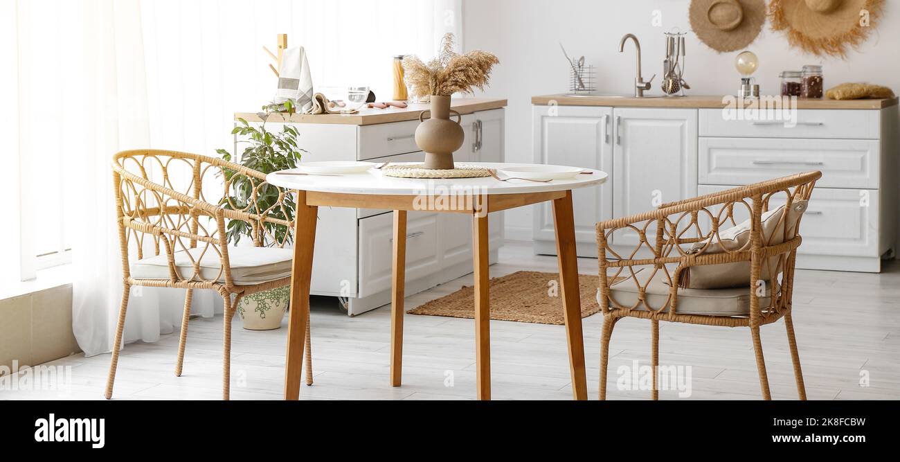 Interior of kitchen with dining table and rattan armchairs Stock Photo ...