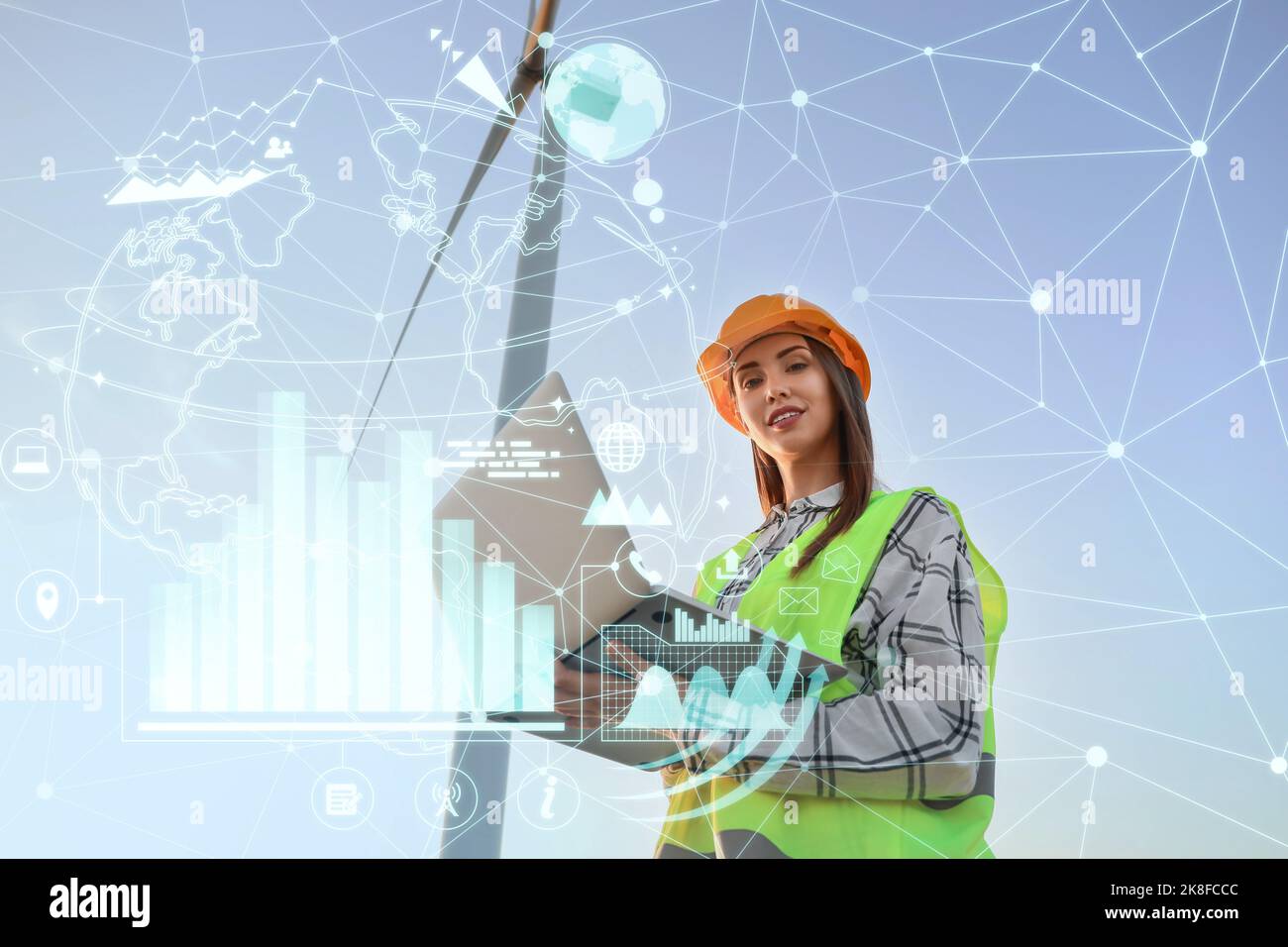 Female engineer with laptop on windmill farm for electric power ...