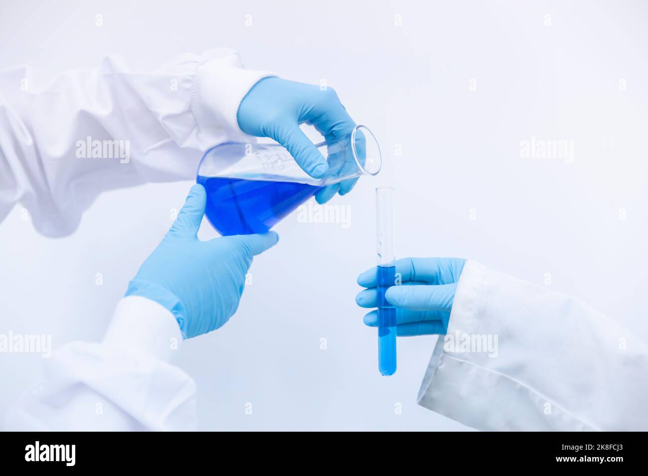 Scientist pouring blue liquid in test tube at laboratory Stock Photo ...